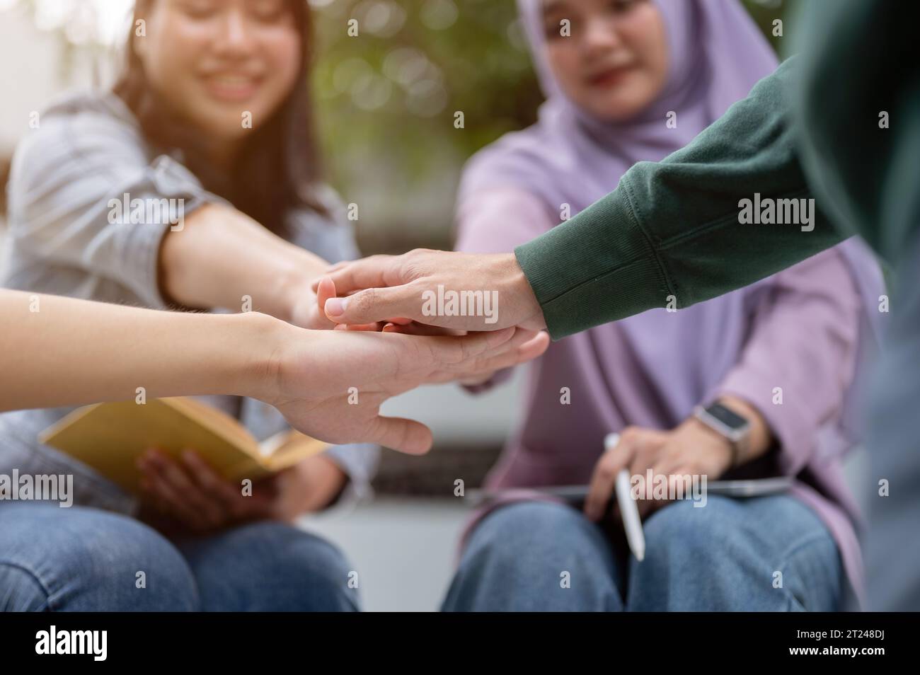 Close-up hand image of a group of cheerful, diverse Asian university ...