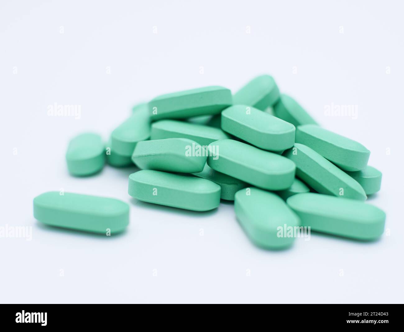 green medical pills and tablets scattered isolated on white background ...