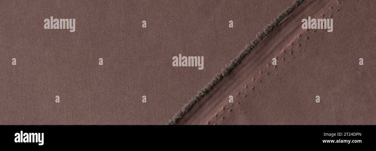 Straight undone seam of brown fabric by torn edge of cloth Stock Photo ...