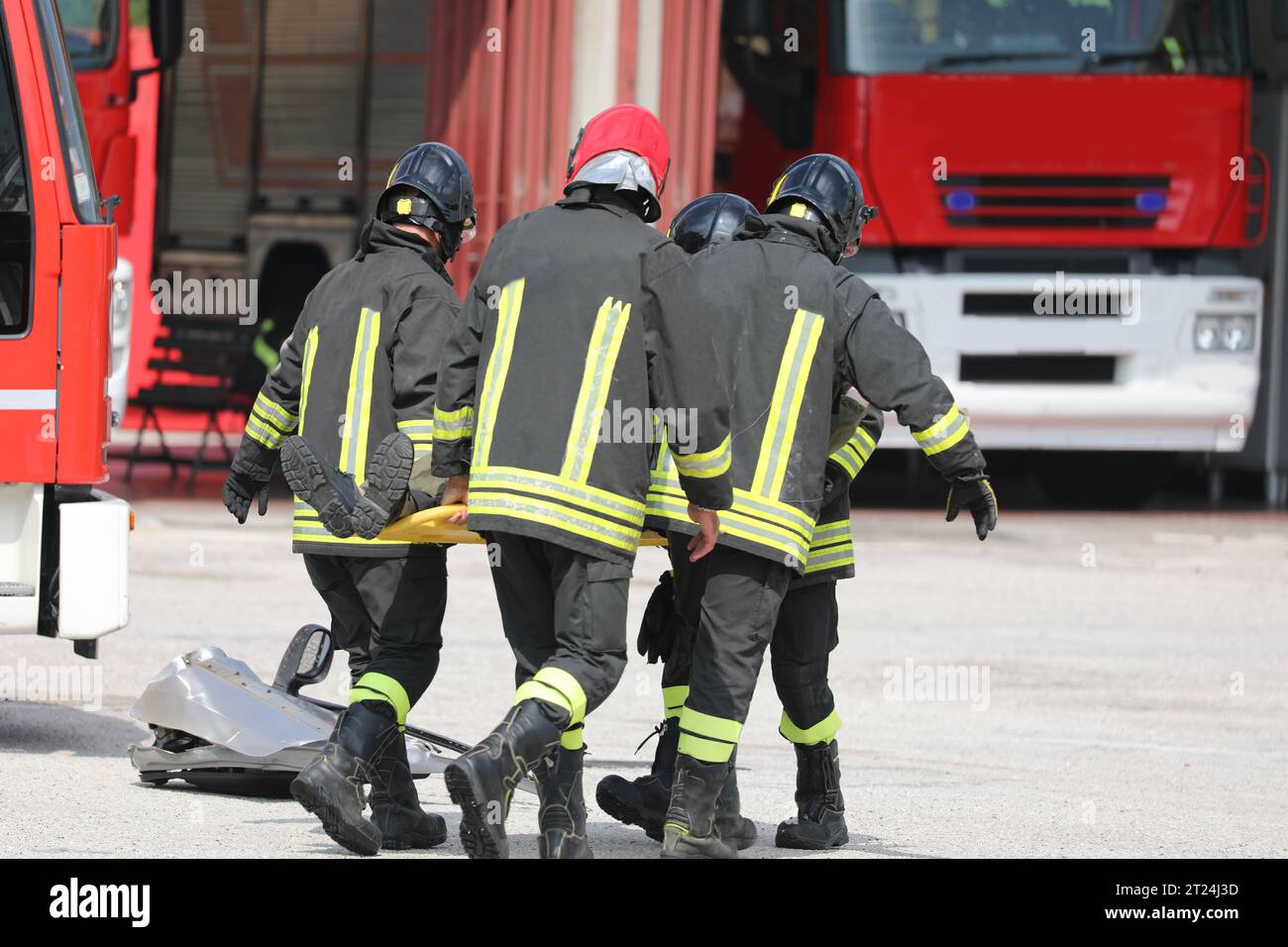 firefighters carrying injured person on stretcher after car accident ...