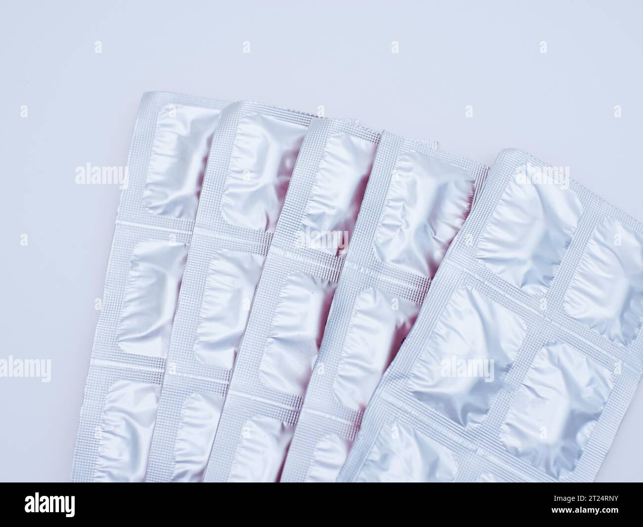 pile of tablets pills in silver blister packaging isolated on white ...