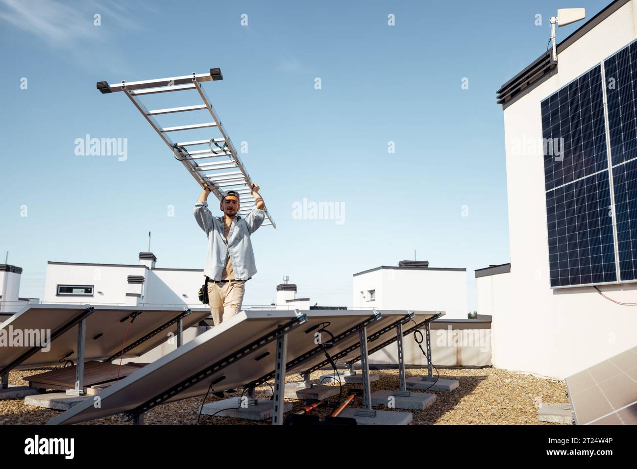 Man carries ladder during solar panels installation Stock Photo - Alamy