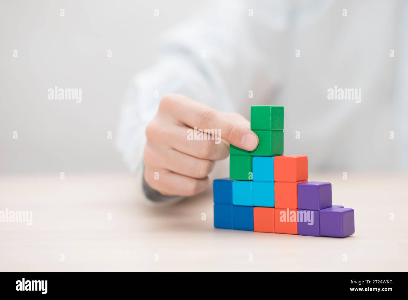 Man's hand stacking colorful wooden blocks. Business development ...