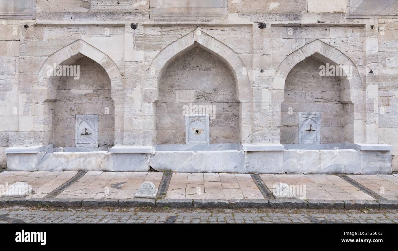 External stone wall of 16th century historic Atik Valide Mosque with ...