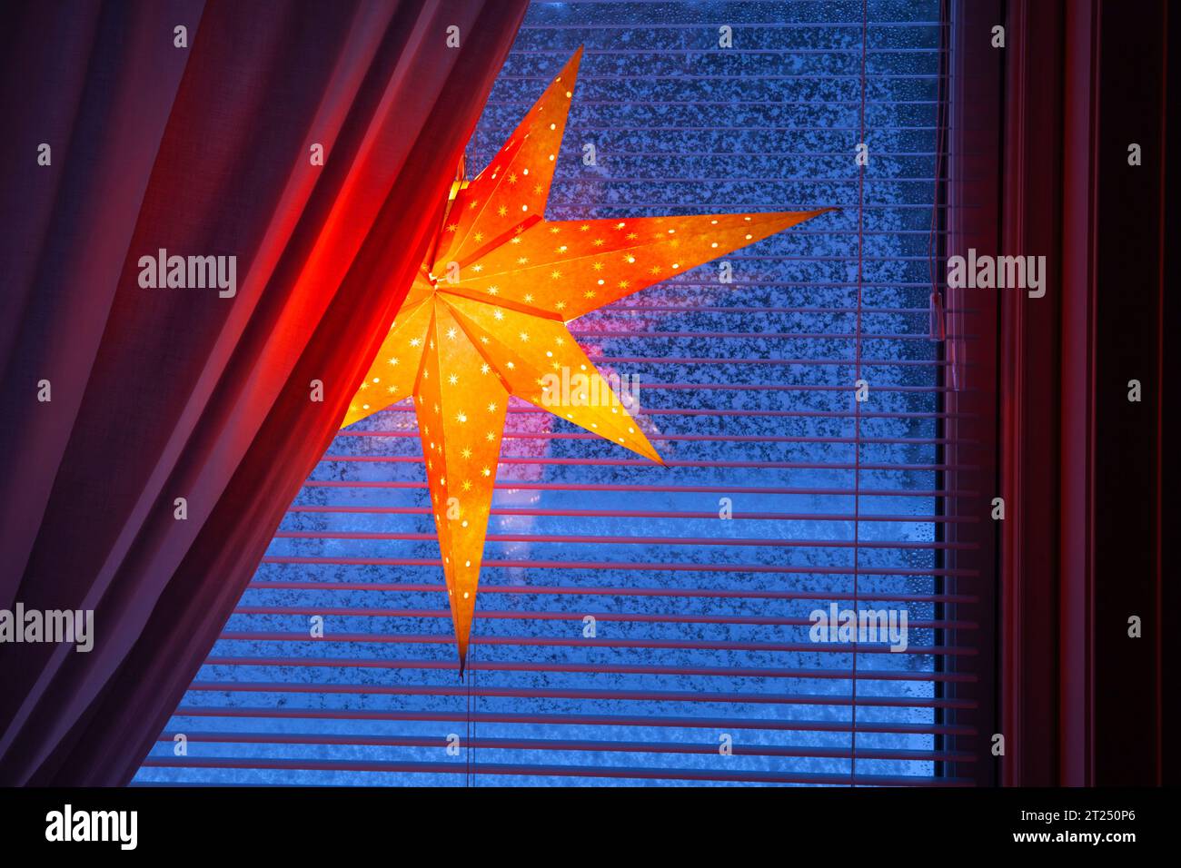An Advent star, Christmas lights in a window. Snowy windows, curtains ...