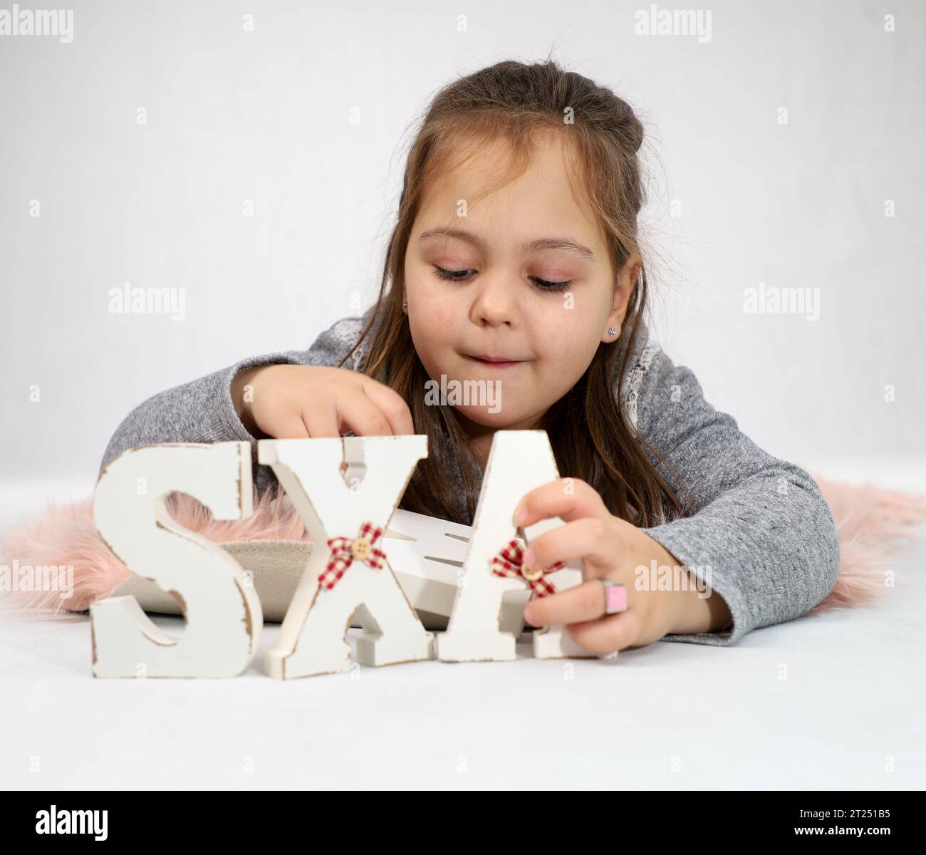 Girl playing with xmas letters Stock Photo - Alamy