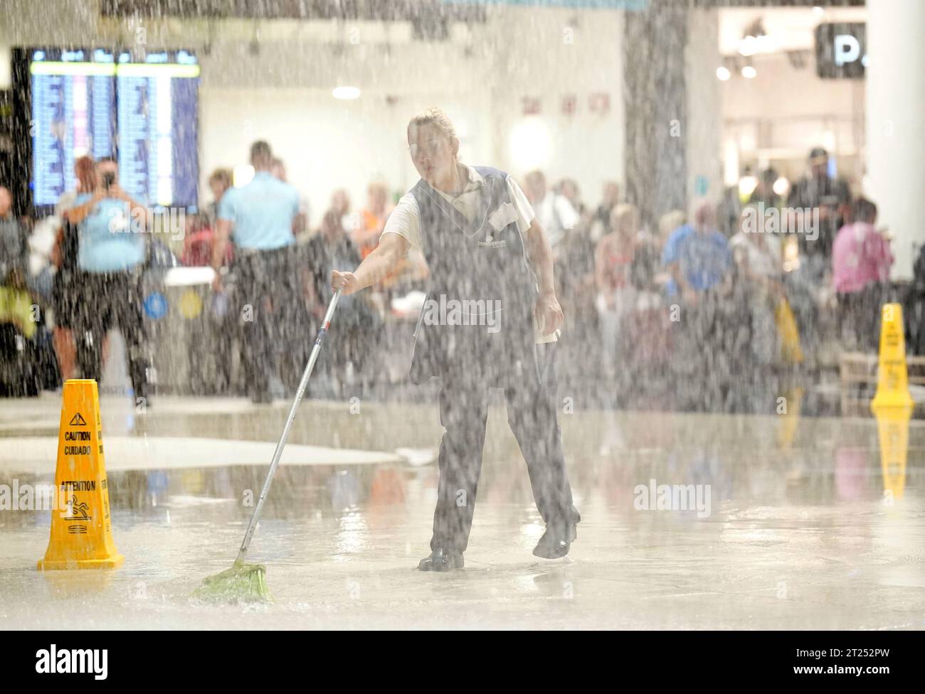 Staff sweep away water from inside Faro airport in Portugal after heavy ...