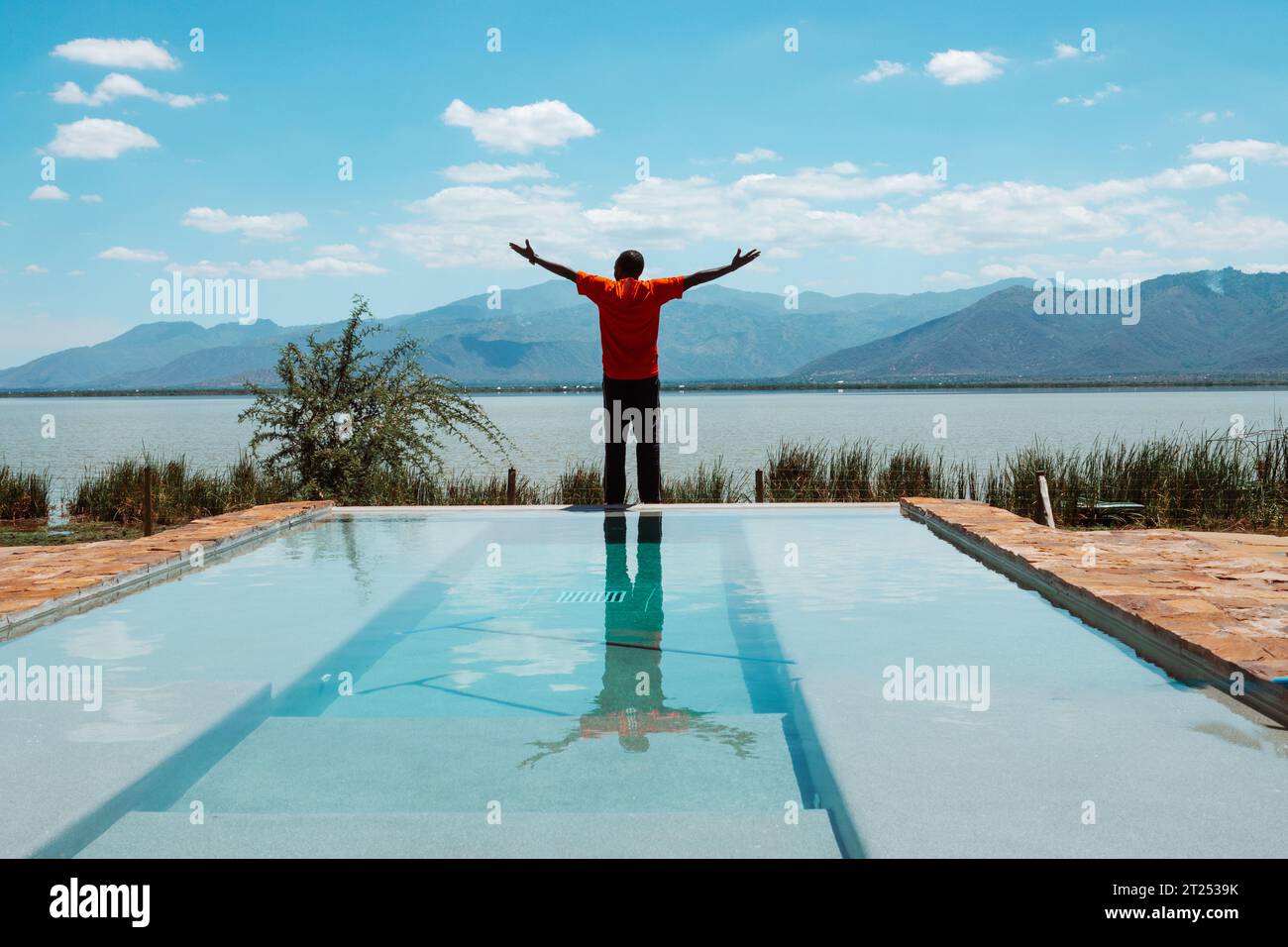 A man in an infinity swimming pool at Lake Jipe at Tsavo West National ...