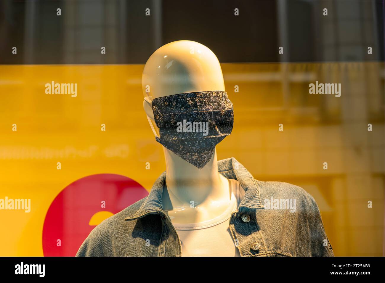 Mannequin with corona mask on face in a fashion shop window in downtown ...