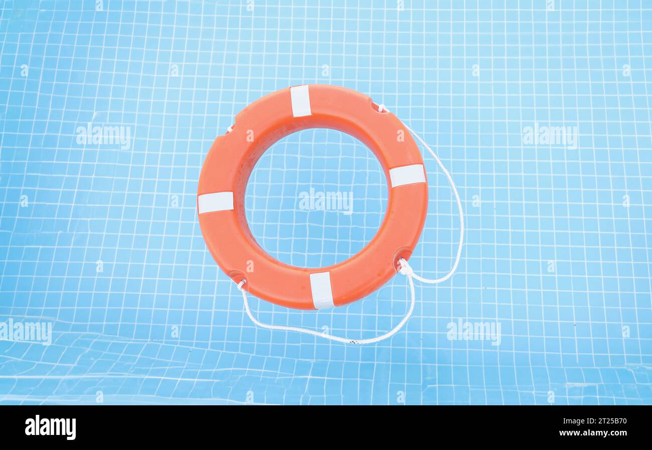 Red safety equipment floating on swimming pool to rescue people from ...