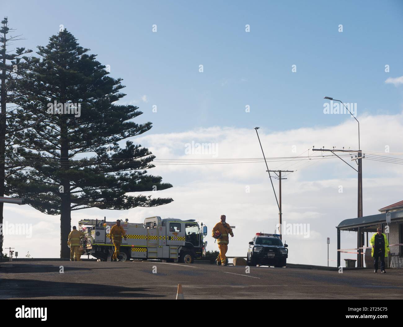 Volunteer firefighters and police on street with fire truck and police ...
