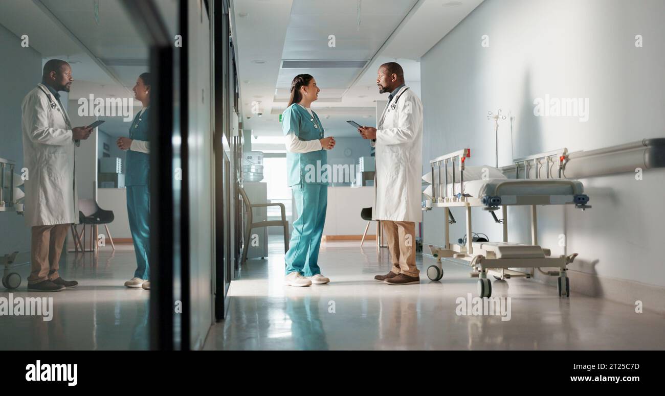 Doctors, man and woman in discussion, hallway and planning for surgery ...