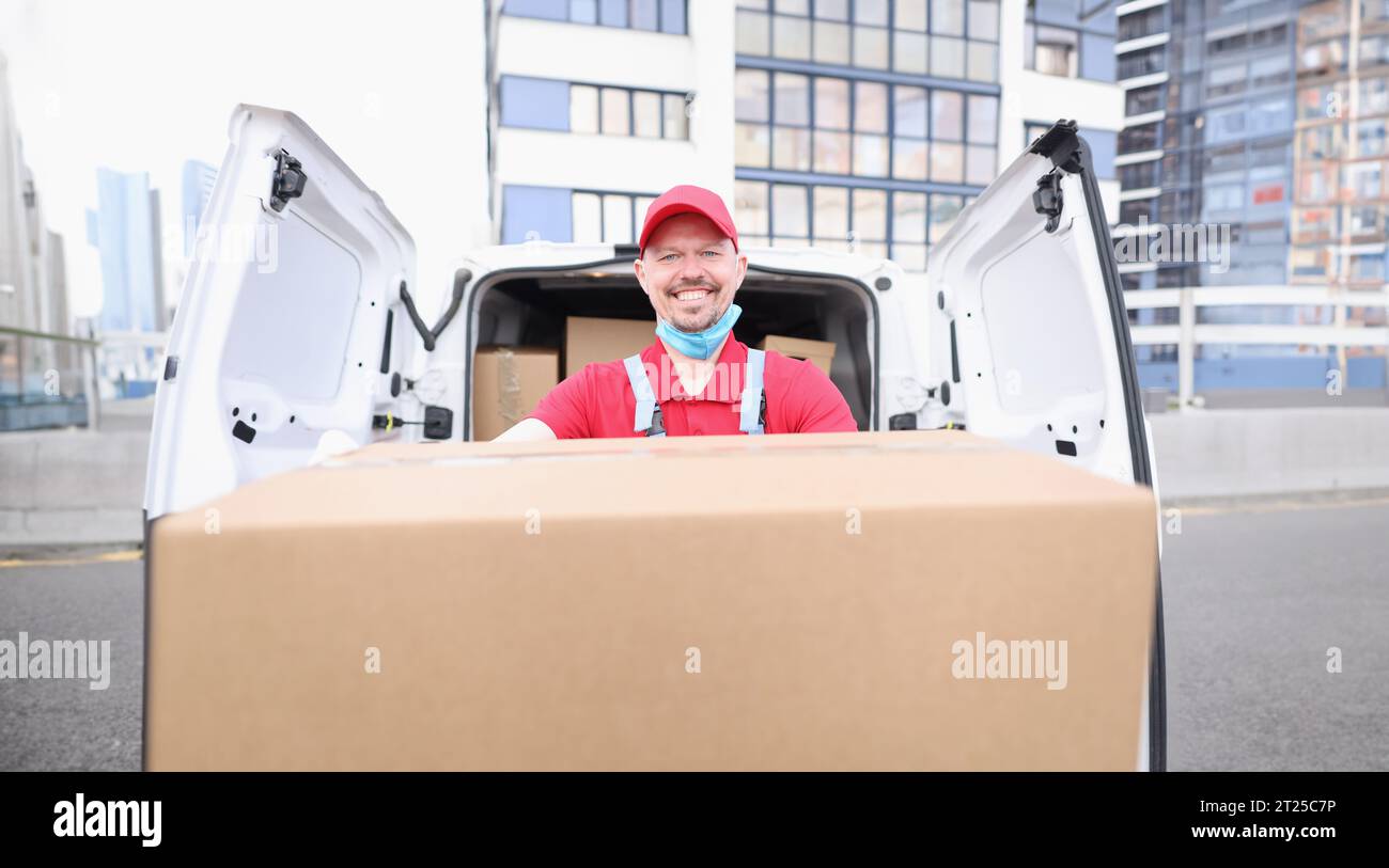 Happy postman worker carry cardboard package, delivery on address Stock ...