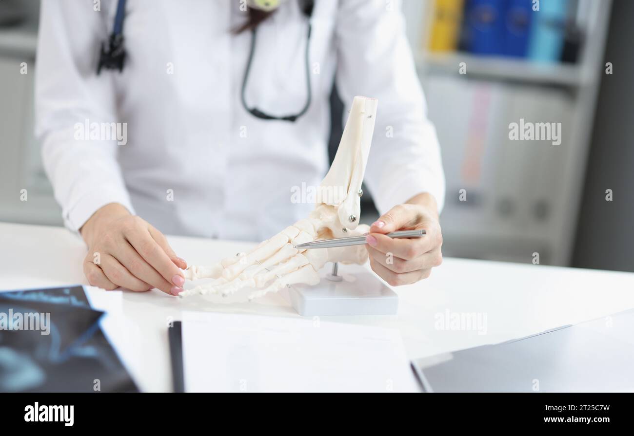 Orthopedic doctor show human plastic feet model, analyzing every bone ...