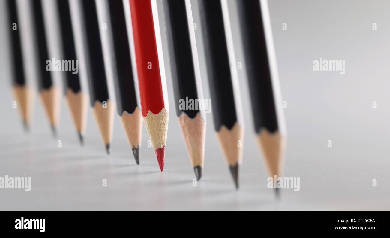 Tips of pencils put on paper in strict order, unique red among ordinary ...