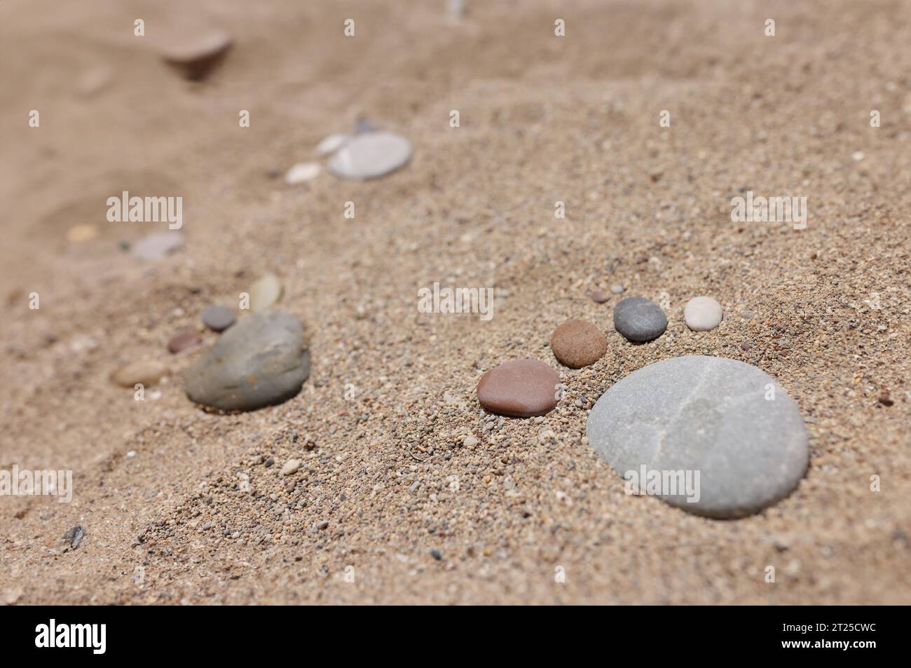 Stone put in human foot shape on sand, hot summer day, coastline, sandy ...