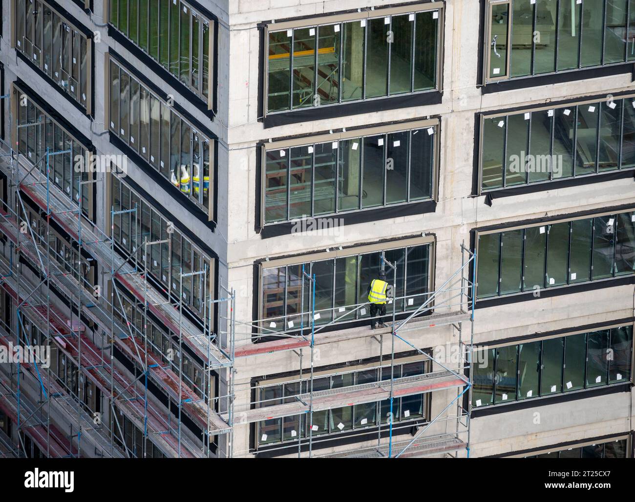Construction worker removing the scaffolding at a commercial building ...