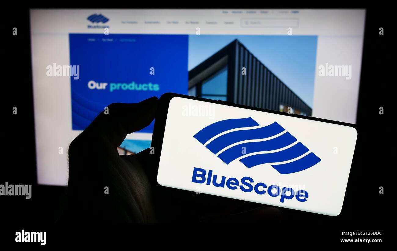 Person holding mobile phone with logo of Australian company BlueScope ...