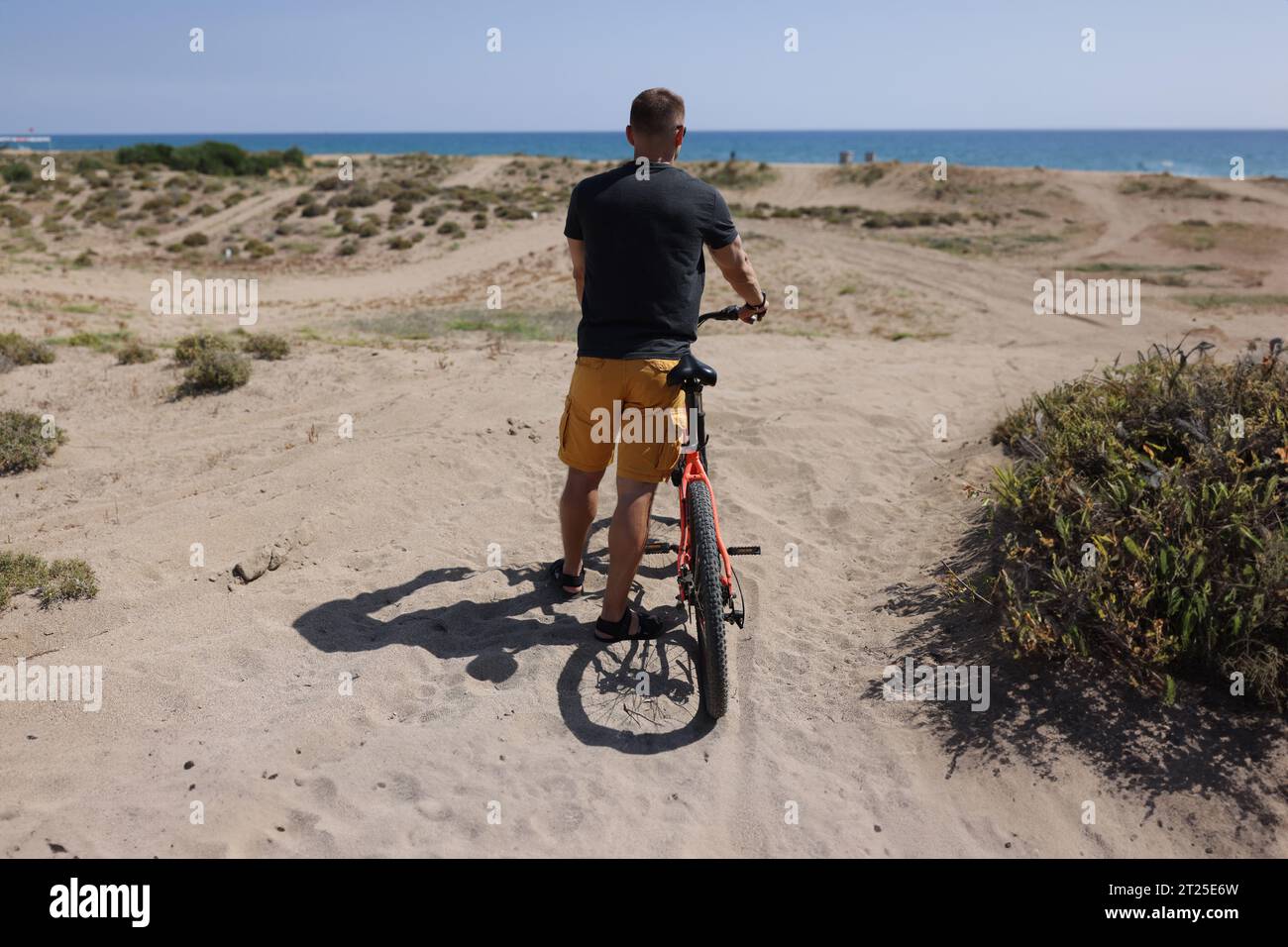 Person stand with back, arriving at his destination after bike ride to ...