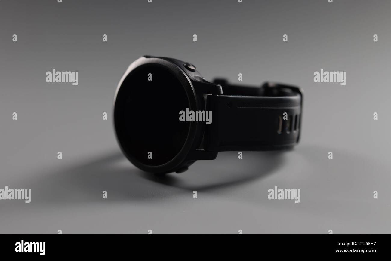 Trendy minimalistic device, black male wristwatch lying on grey ...