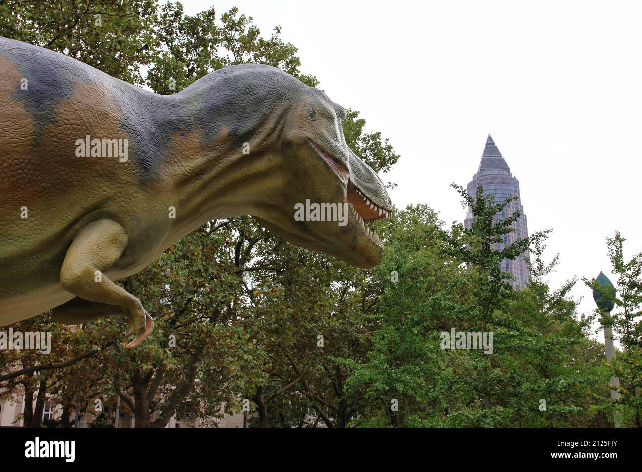 An adult Tyrannosaurus Rex dinosaur statue with a tall tower structure ...