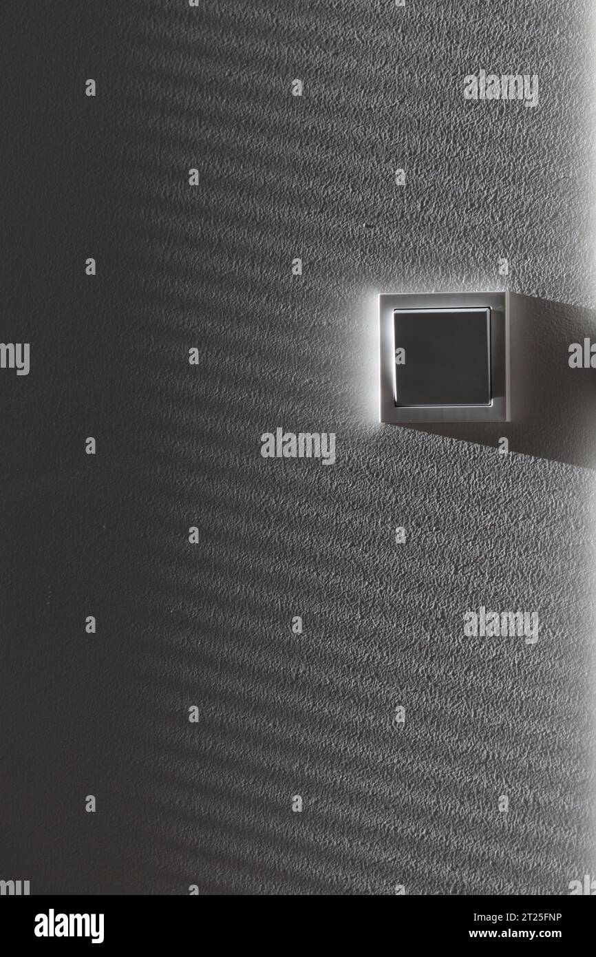 Light switcher on the white wall beneath rays of light vertical Stock ...