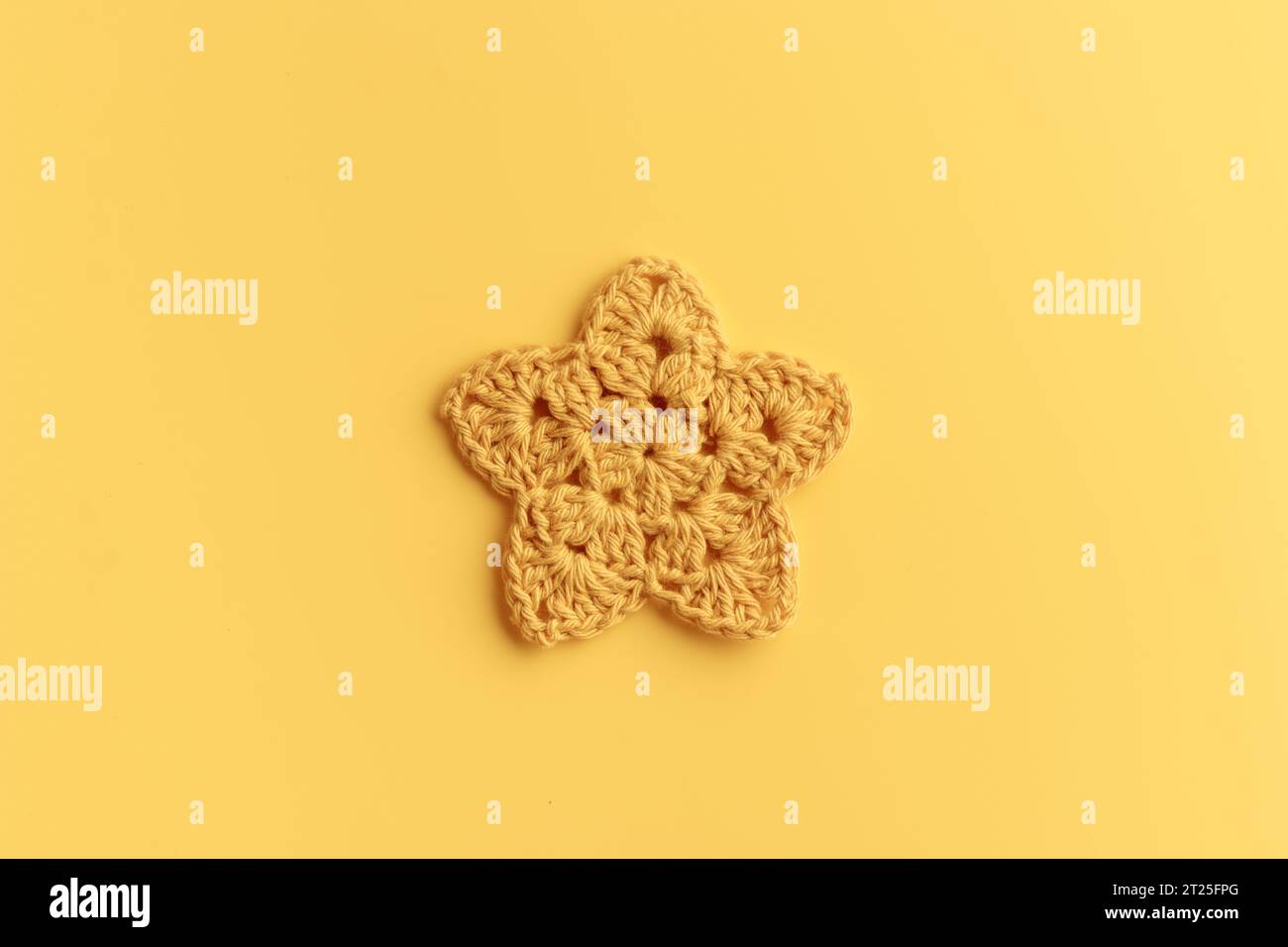 The yellow crocheted star on a yellow background Stock Photo - Alamy