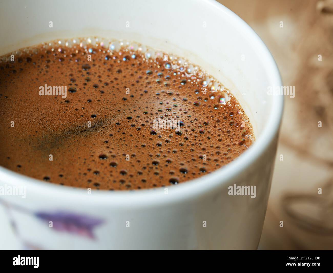 Macro image of coffee in cup, with a lot of bubbles on top, close-up ...