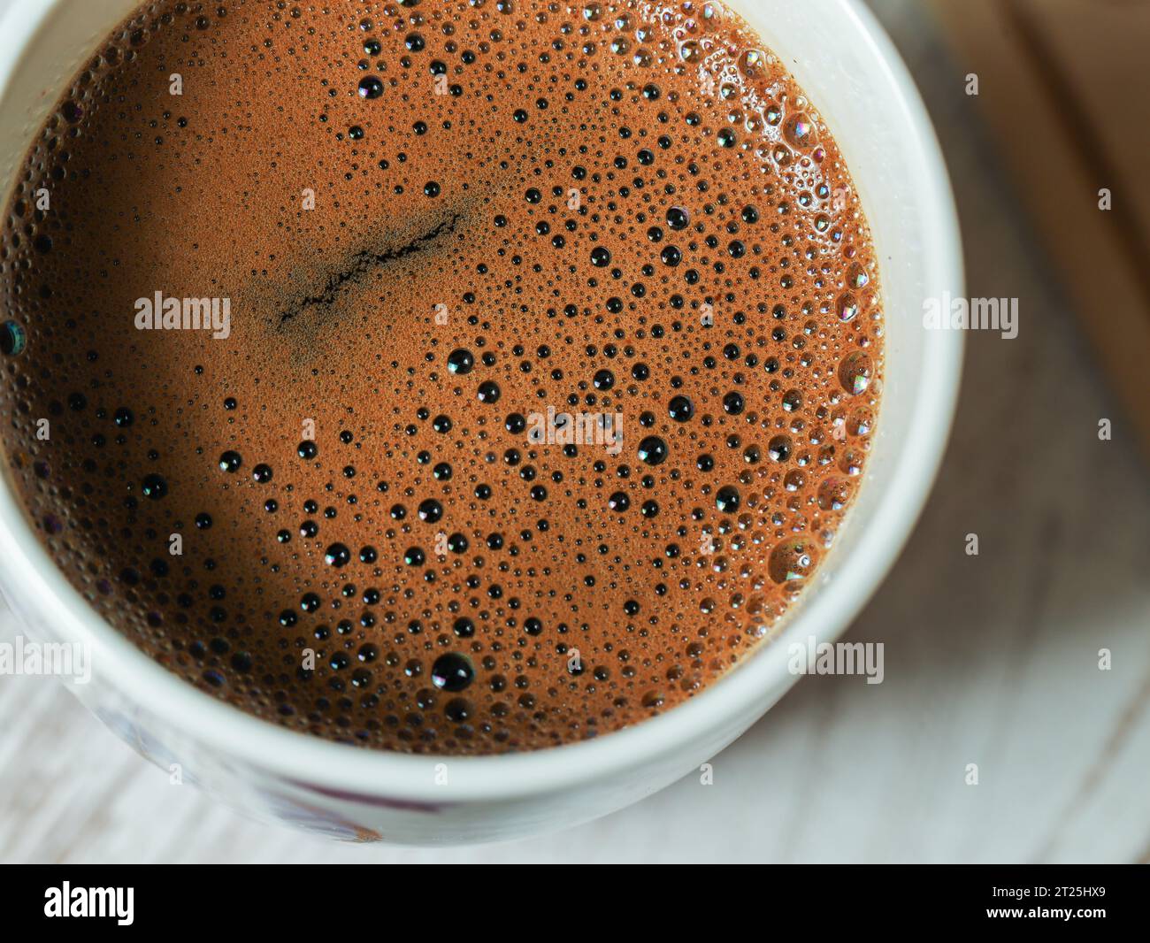 Macro image of coffee in cup, with a lot of bubbles on top, close-up ...