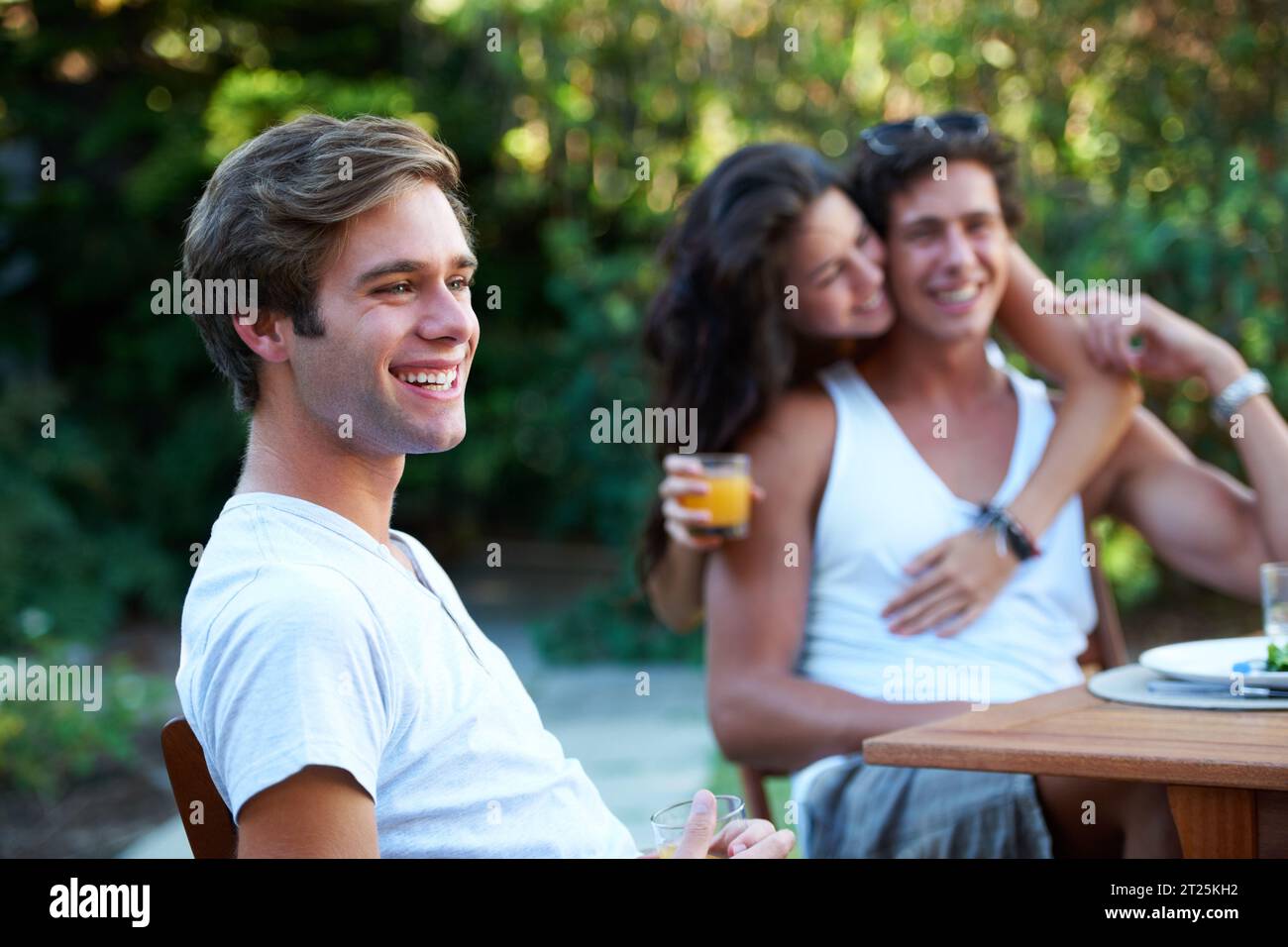 Young man, laughing and friends in a backyard at home with bbq and ...