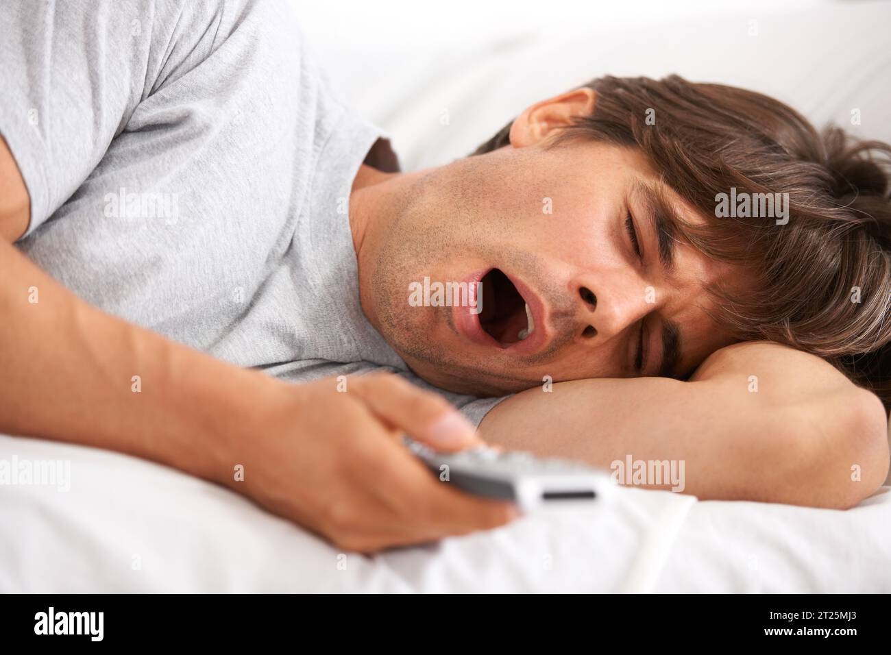 Tv, yawn and tired man in bed with remote control for streaming movies ...