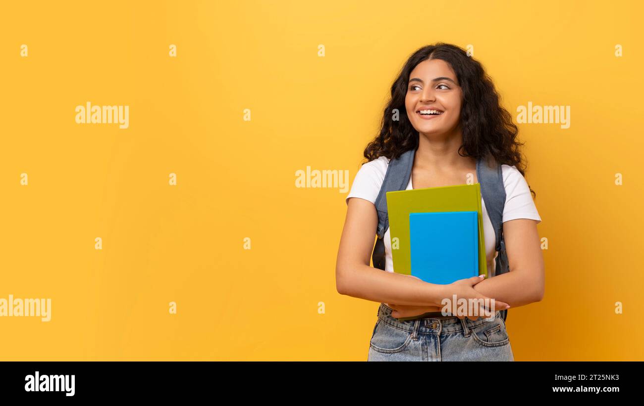 Young smiling happy indian woman student on yellow Stock Photo - Alamy