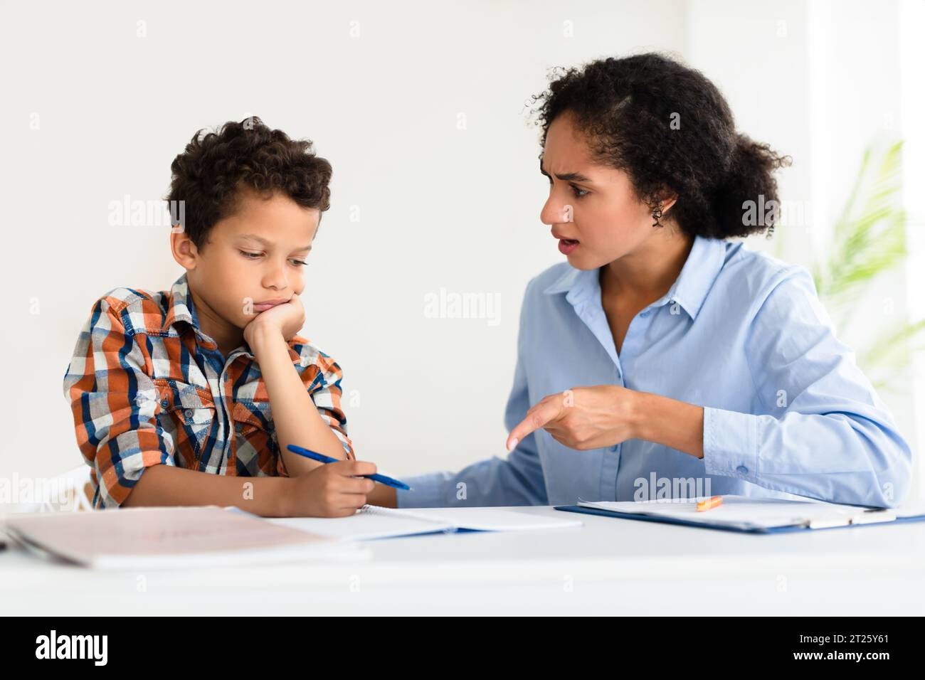 Teacher woman scolding student boy in modern classroom interior Stock ...