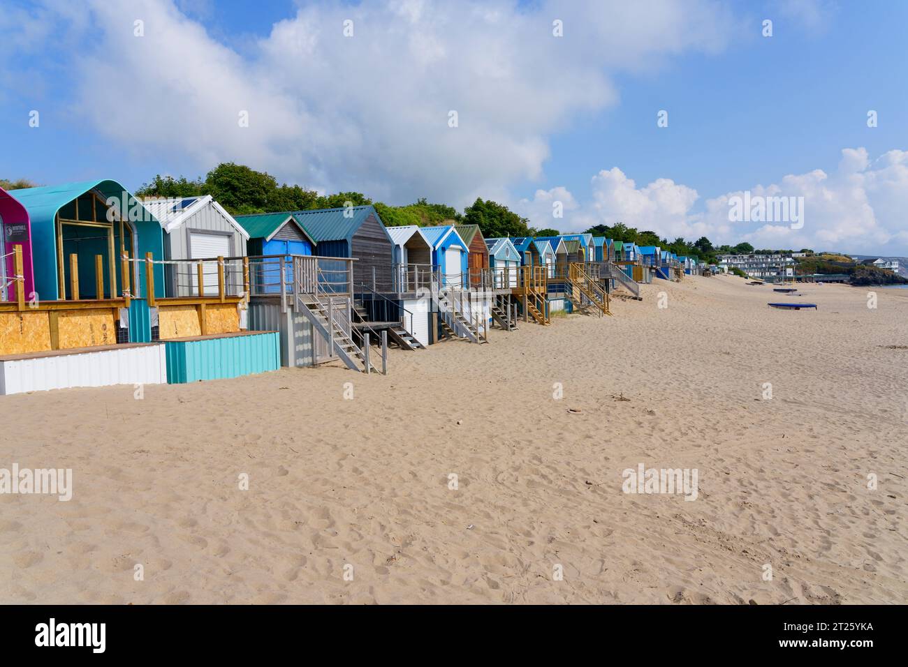 Brightly coloured beach huts in various shapes and sizes down the ...