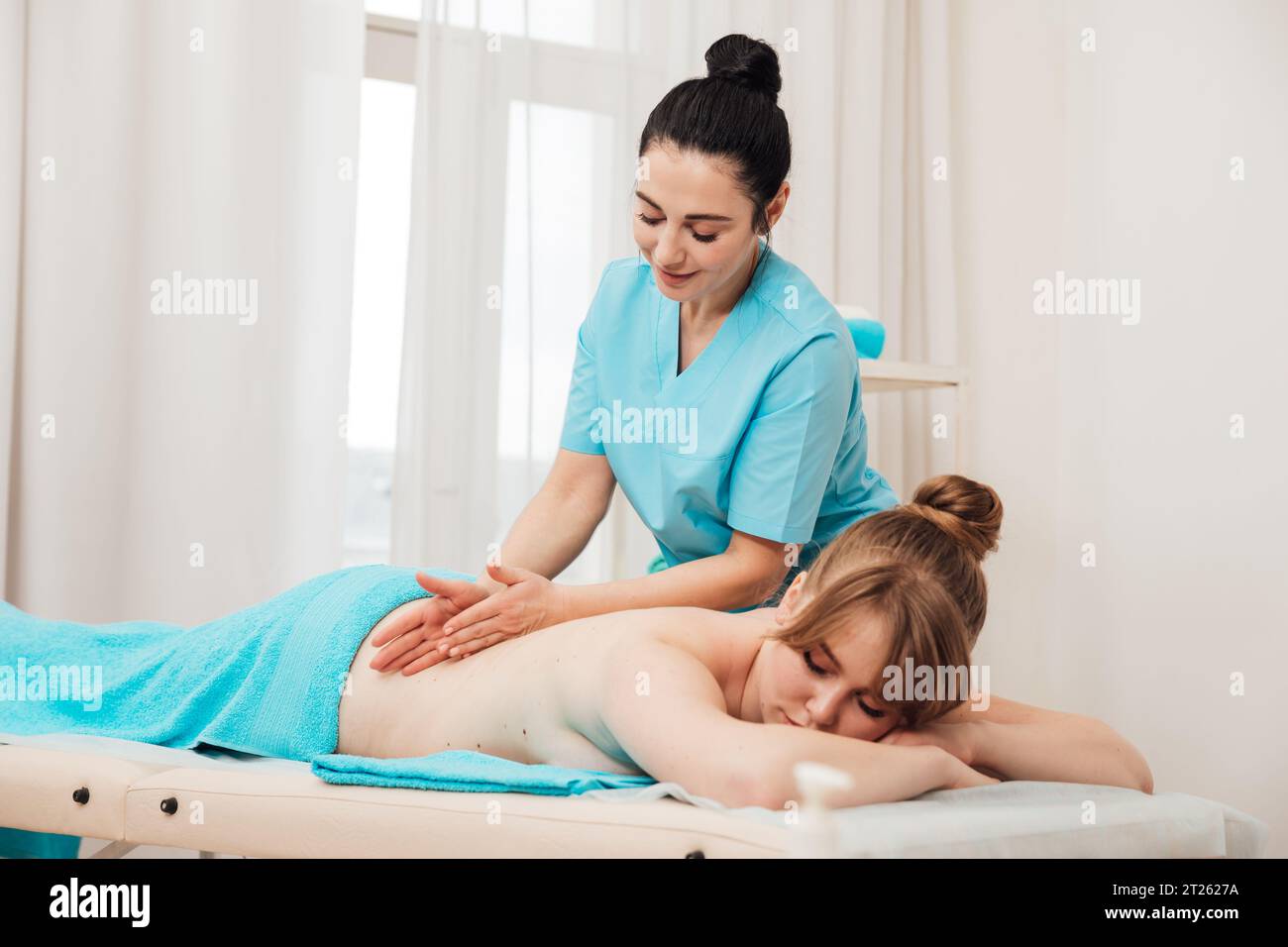 manual therapy healthy back woman massages shoulders to client in massage room Stock Photo - Alamy