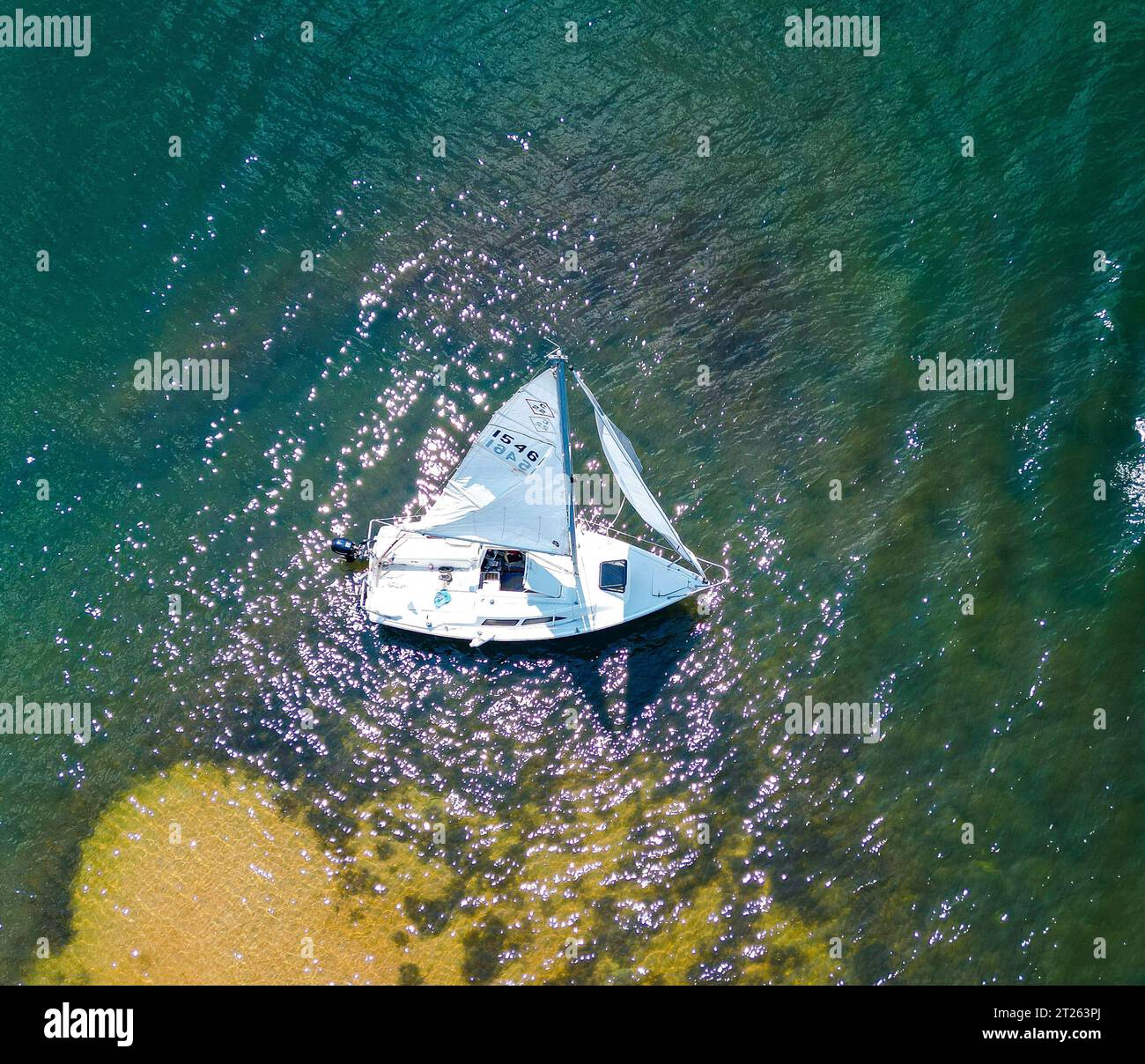 A picturesque scene of a Catalina 22 sailboat sailing across a lake ...