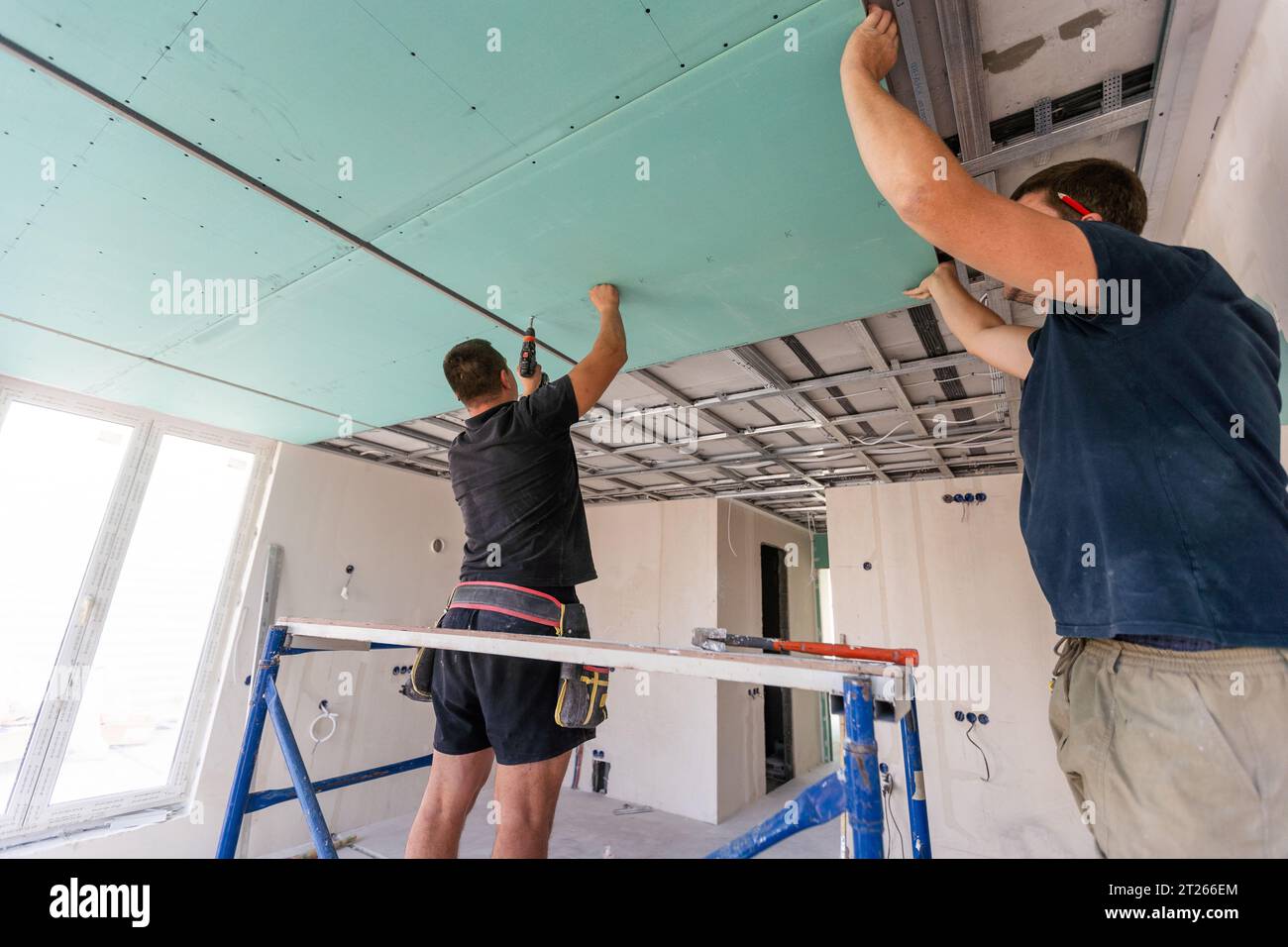 Construction worker ceiling work installation Stock Photo - Alamy
