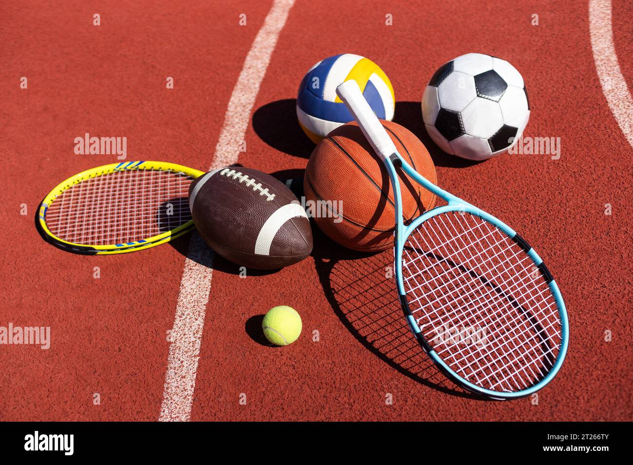 A variety of sports equipment including an american football, a soccer ...