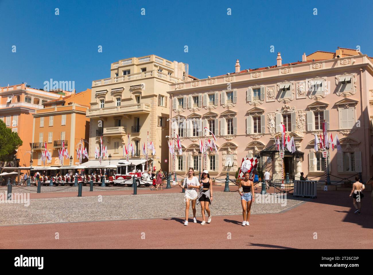 Tourist visitors enjoy Place du Palais, Monaco. Building to right is La ...