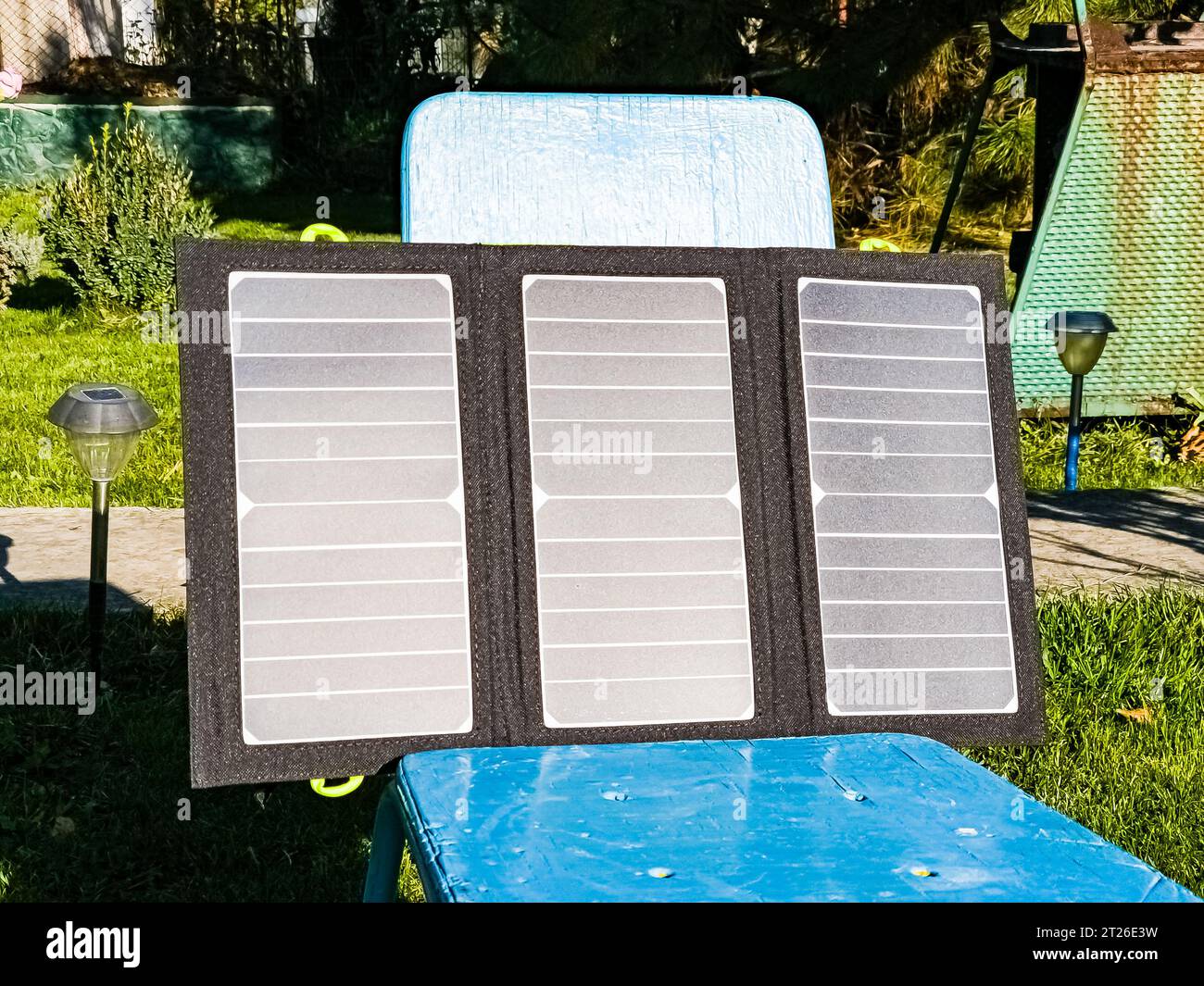 Charging a portable solar battery from the sun at a summer camping site ...