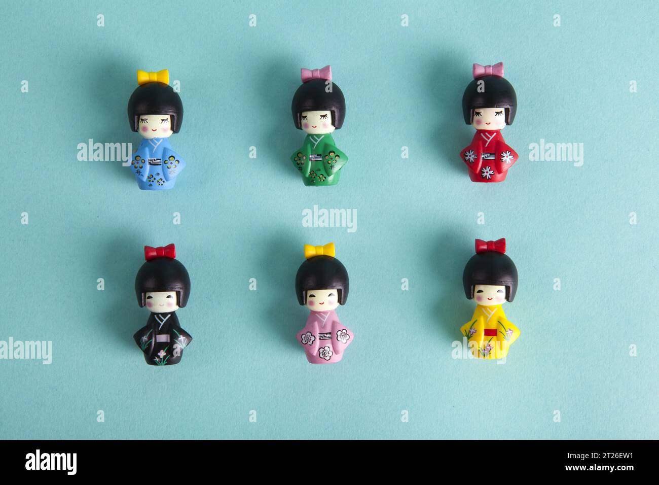 a collection of 6 wooden kokeshi dolls aligned in rows and columns on a ... a collection of 6 wooden kokeshi dolls aligned in rows and columns on a ...