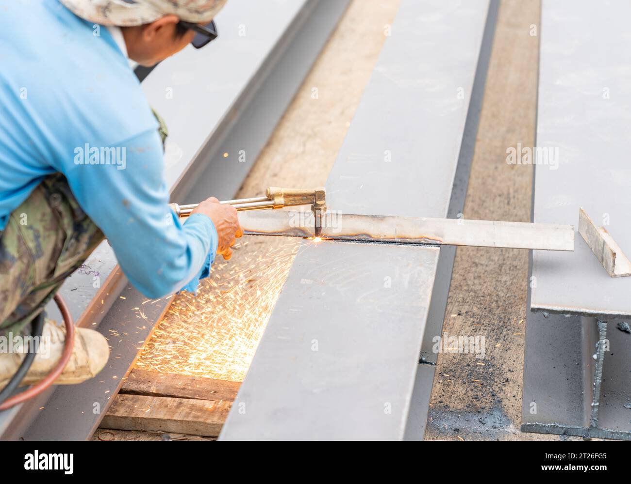 Worker cutting metal beam with acetylene torch in construction site ...