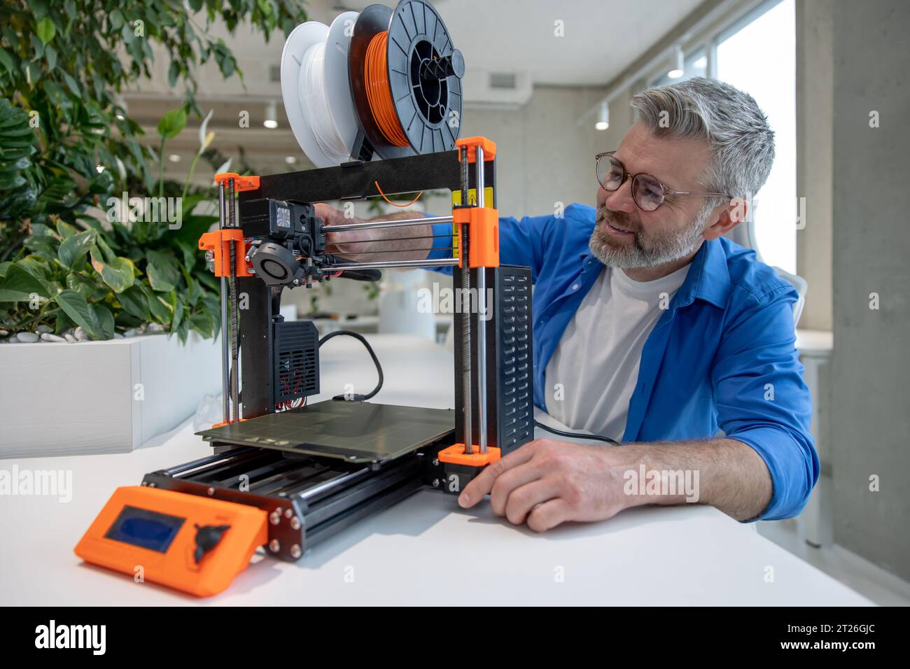 Modern 3D printer equipment and man working with it in office Stock ...