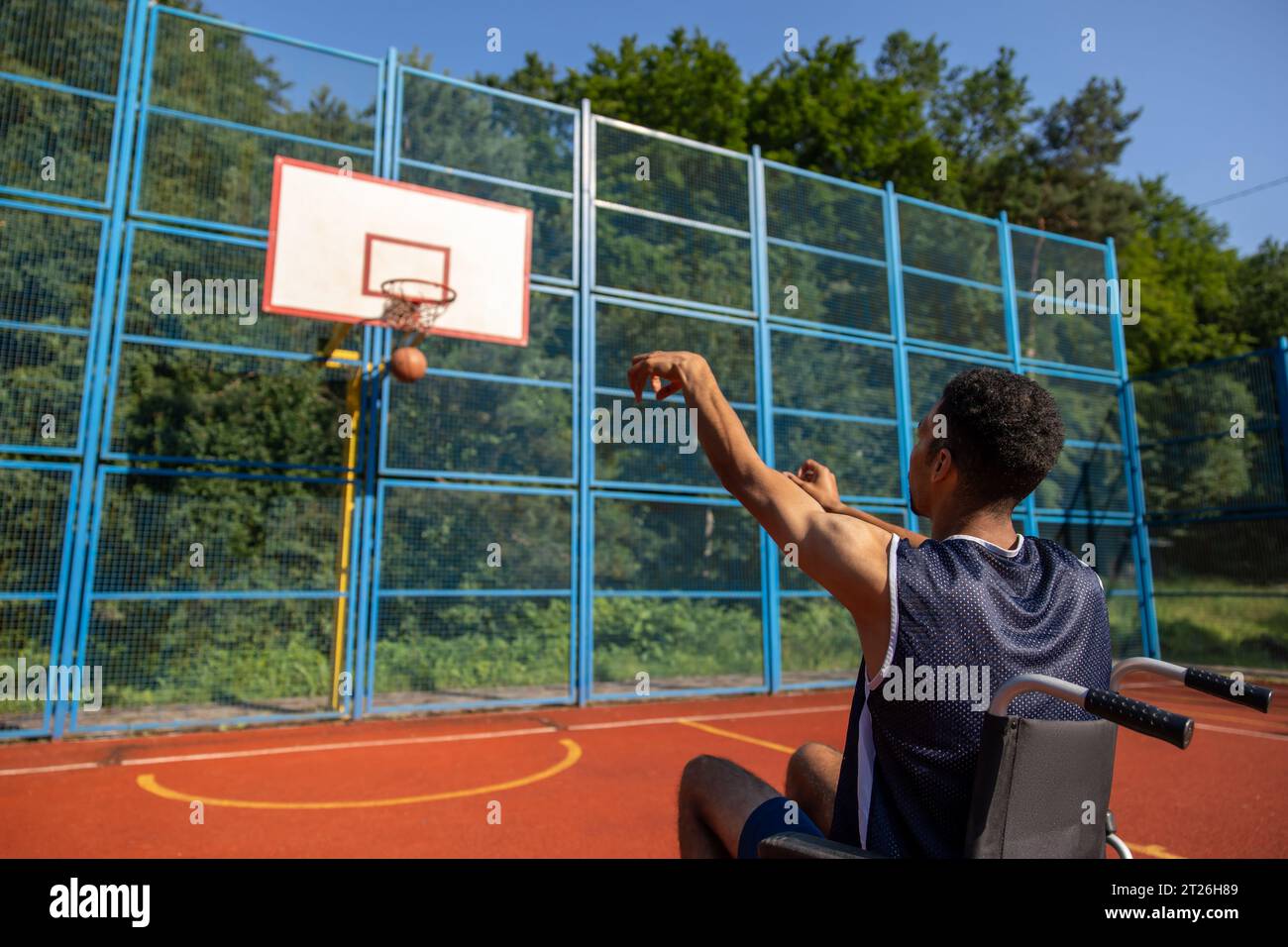 Man in wheelchair, person with disability throwing the ball into the ...