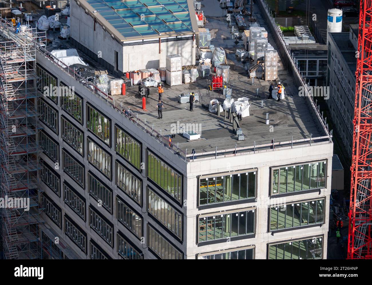 Birdseye view of roofer waterproofing the flat roof of a commercial ...