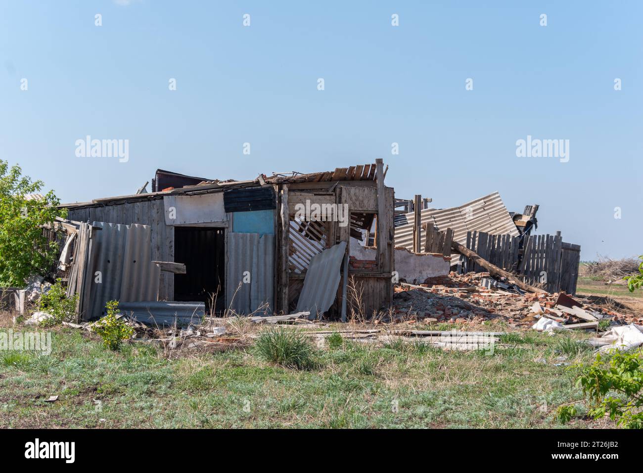 An old ruined wooden house. Broken walls, a ruined roof. Piles of ...