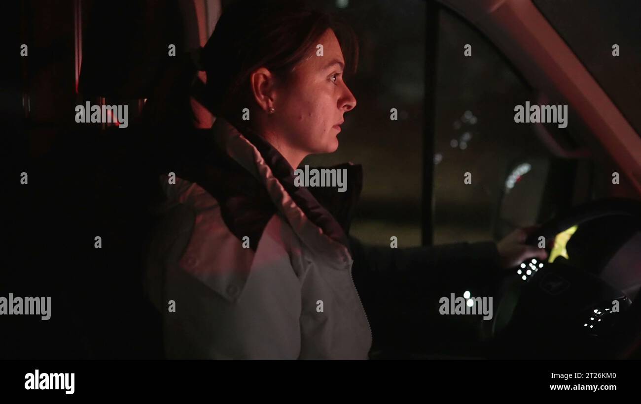Woman driving moving truck at night. Female driver paying attention to ...