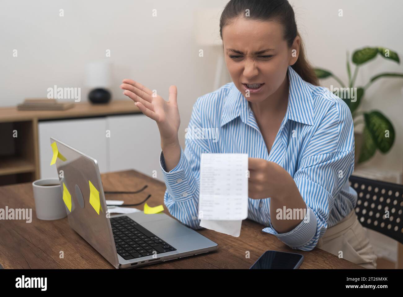 Angry woman looks at document with bank accounts frustrated by big ...