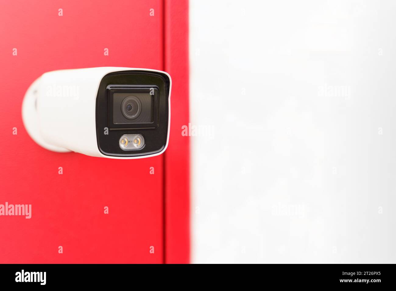CCTV camera on a red background, next to a white background for text ...