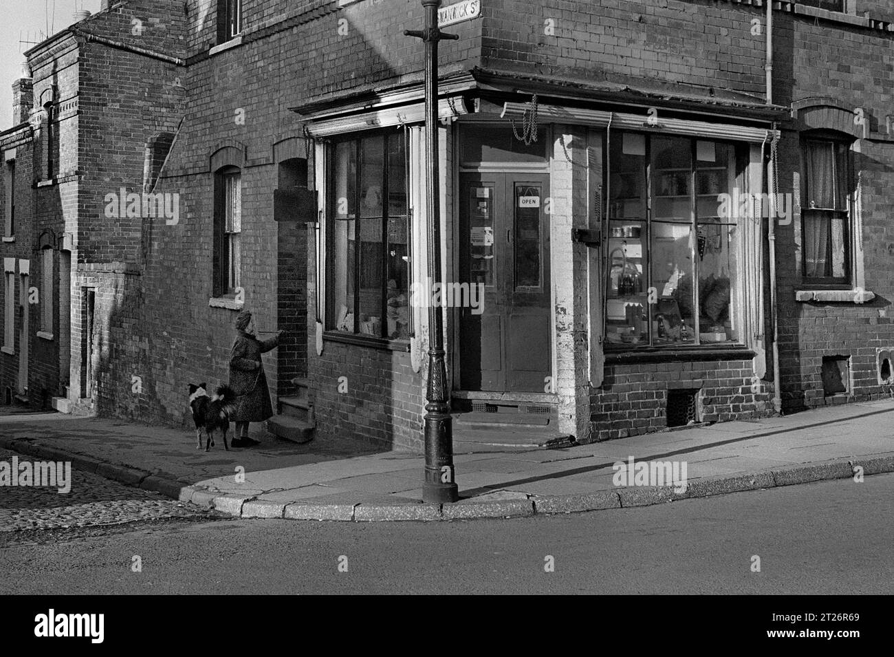 Elderly lady and her dog stood beside a corner shop on Swanwick Street ...